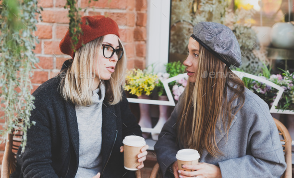 Young female best friends talking to each other discussing interesting ...