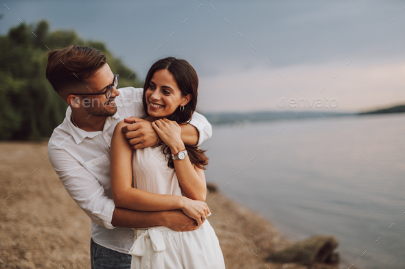 Two people in love smiling and hugging each other. Stock Photo by bnenin