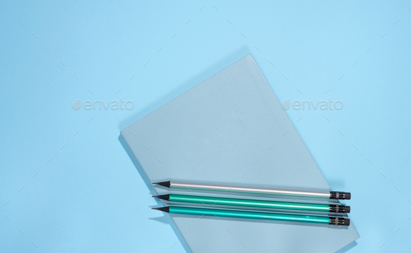 Blue notepad and wooden pencils on a blue background, top view Stock ...