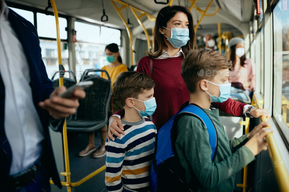 Mother and kids wearing protective face masks while commuting by public ...