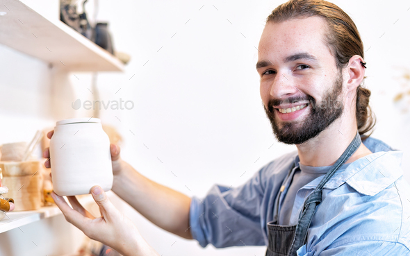 Pot making man arrange the ceramic clay pot on the shelf in pottery ...