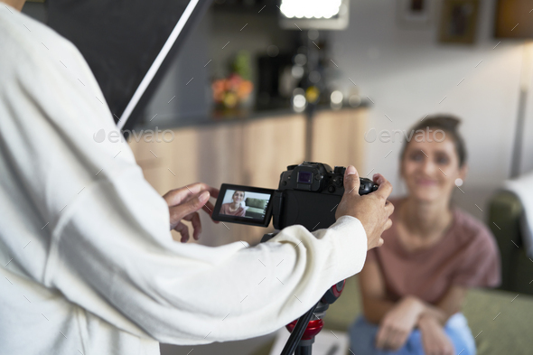 Caucasian woman being recorded and unrecognizable woman as camera ...