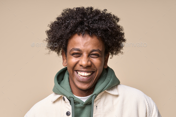 Happy African gen z guy laughing isolated on beige background, closeup ...