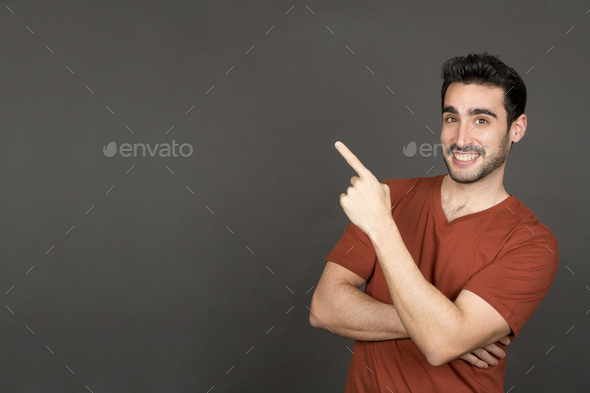 Man in studio pointing at the blank space Stock Photo by sloomstudio