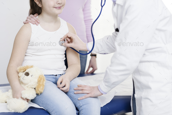 Doctor examining a cute smiling girl with a stethoscope Stock Photo by ...