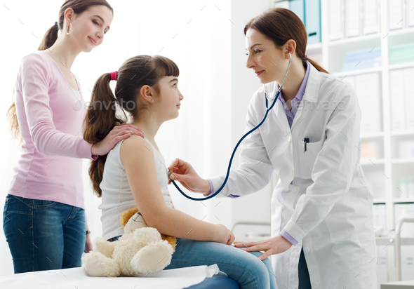 Doctor examining a cute smiling girl with a stethoscope Stock Photo by ...