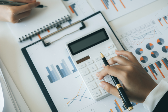 Businessman using a calculator to calculate numbers on a company's ...