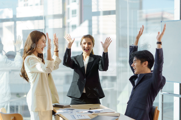 Young Asian business people raising his hand to congratulate excited ...