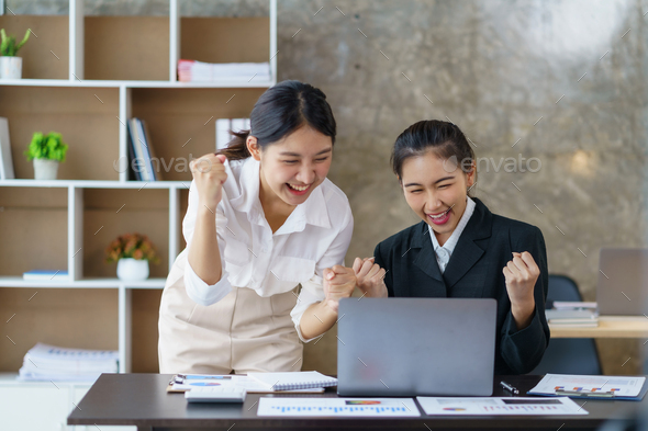 Happy two Asian business women raising their hand to congratulate their ...