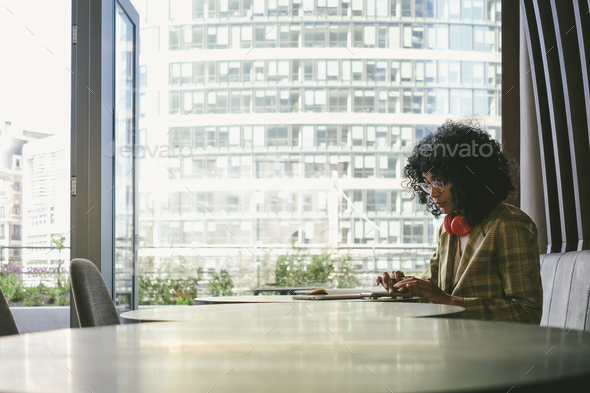 Brazilian dandy lady sitting and working with tech gadgets at coworking ...