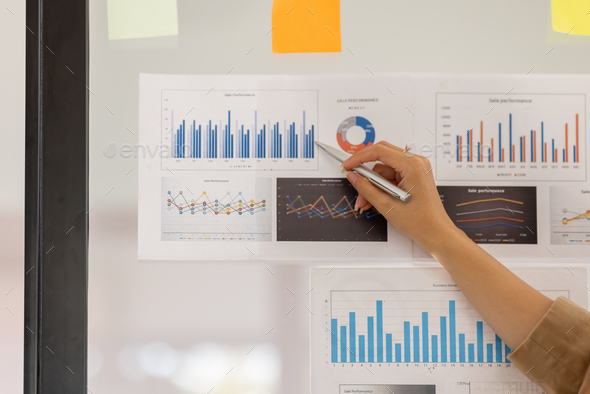 Young Business Asian woman using sticky notes and graph chart in glass ...