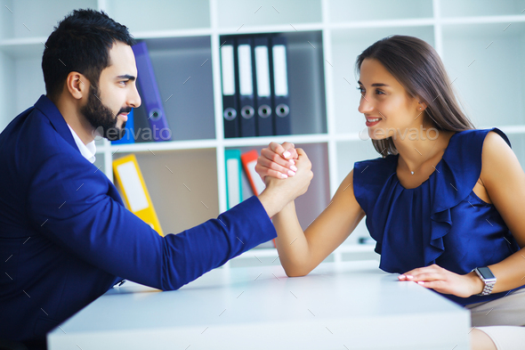 Side view portrait of man and woman armwrestling Stock Photo by maksymiv