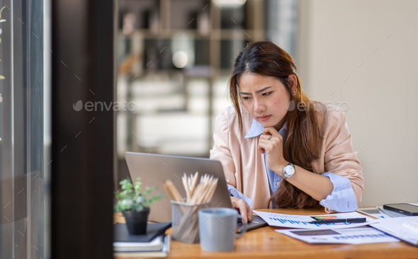 Thai Asian businesswoman working inside office with documents and ...