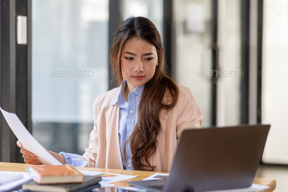Thai Asian businesswoman working inside office with documents and ...