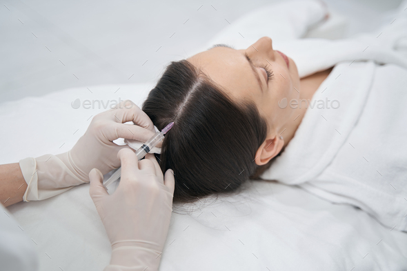 Doctor hands doing injection into woman scalp in beauty salon Stock ...