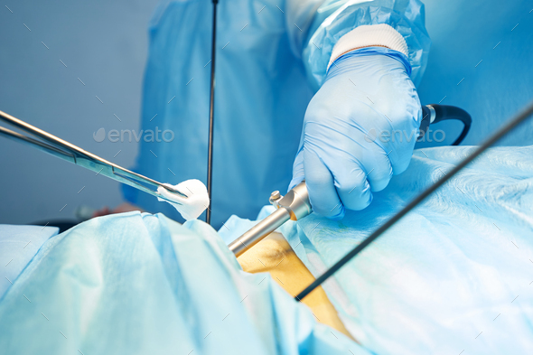 Gauze in surgical forceps moving to abdomen incision during operation ...