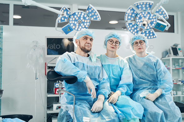 Team of surgical department staring at camera from operation table ...