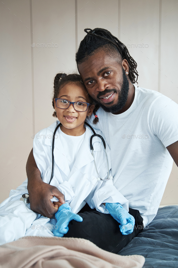 Adult African American man hugging a little girl Stock Photo by svitlanah