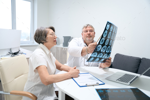 Elderly man and woman are studying MRI scans in diagnostic room Stock ...