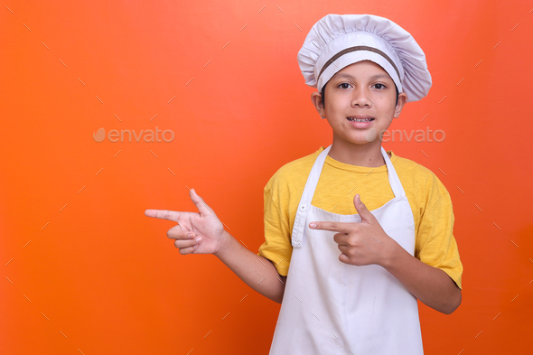 Little chef boy points to the side Stock Photo by Queenmoonlite35