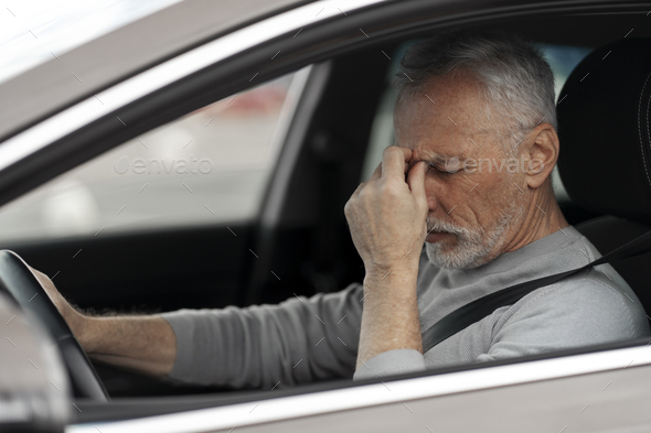 Overworked 60-70 years old, senior man, taxi driver feeling headache ...