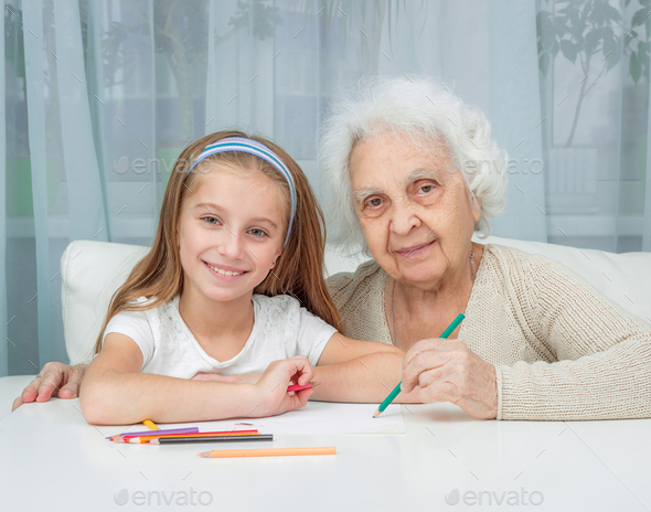 little girl and her grandmother drawing with pencils Stock Photo by tan4ikk