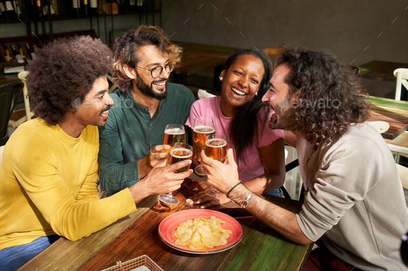 Group of colleague workers toast with beer in the restaurant bar after ...