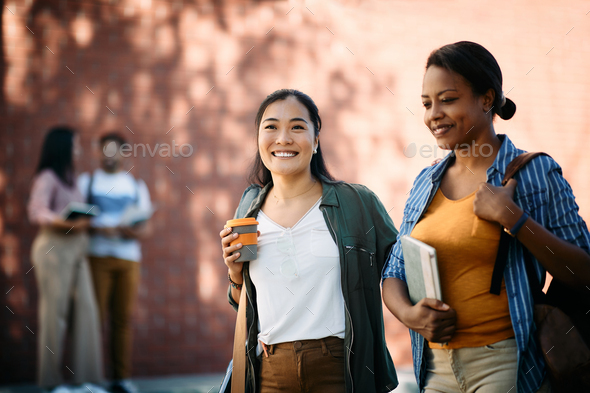 Happy Asan student and her black female classmate going to lecture at ...