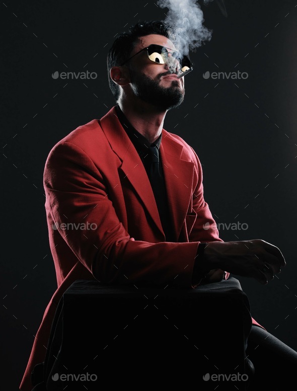 Man in red suit, smoking and fashion with style, trendy and guy on dark ...