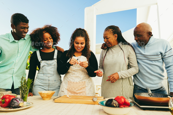 Happy african family cooking together in outdoor kitchen at home ...