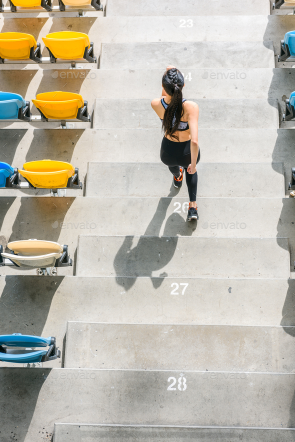 elevated view of sportswoman running on stadium stairs, young girl ...
