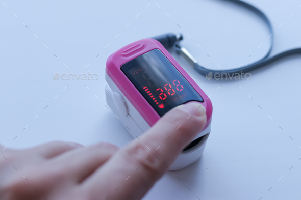 Finger presses a button on the pink pulse oximeter Stock Photo by ...