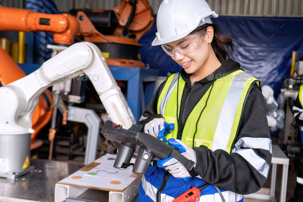 Young female asian service engineer holding robot controller operate ...