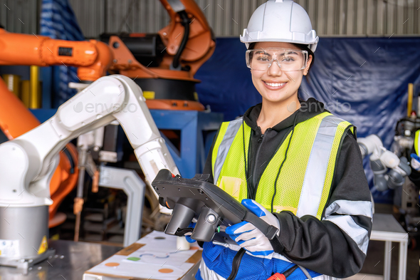 Young female asian service engineer holding robot controller operate ...