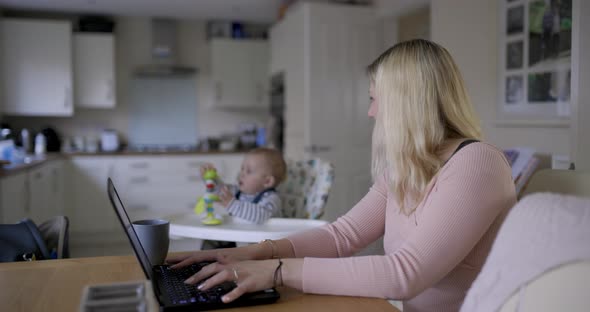 Mother working from home and playing with her newborn baby boy, Stock ...