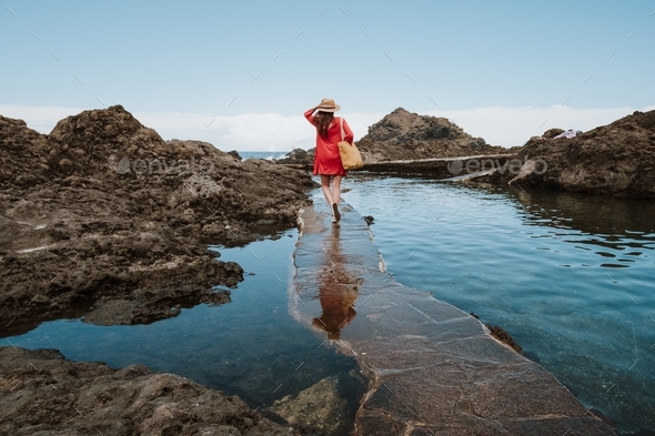 Female walking on a stone pathway surrounded with rocky mounds and ...