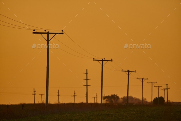 Scenery of sunset in an overhead power line Stock Photo by wirestock