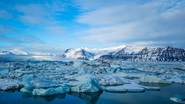 Landscape of hills and a lake covered in ice under the sunlight in ...