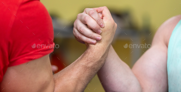 Close-up shot of strong mans' muscles during an arm-wrestling fight ...