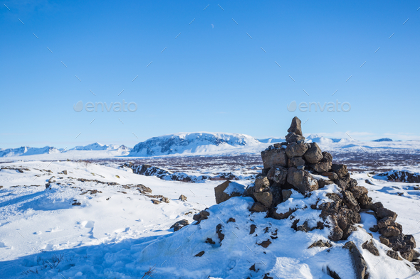 Landscape of a field covered in rocks and snow under the sunlight in ...