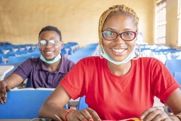 Shallow focus of two young African students wearing facemasks and ...