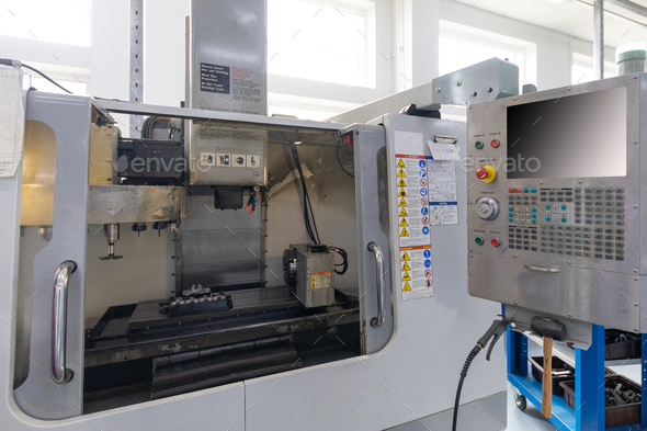 Modern computerized factory equipment processing metal parts with ...