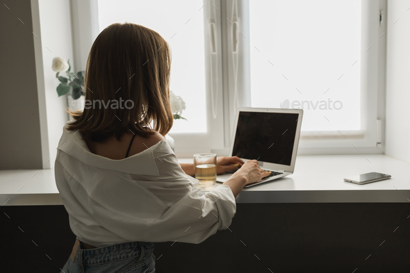 Close up of back view young pretty concentrated woman typing and ...