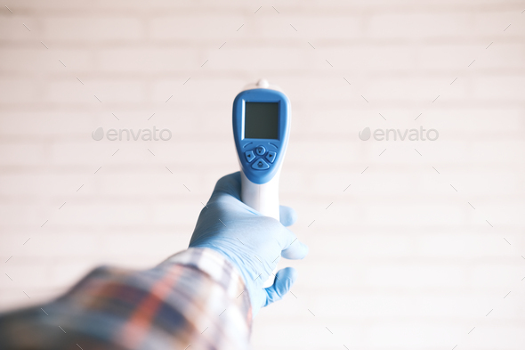 Hand holding infrared thermometer to measuring temperature. Stock Photo ...