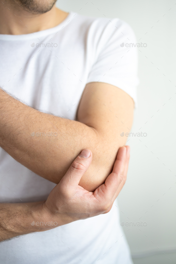 Man holding hands. Elbow pain. focus is highlighted in red. Close ...