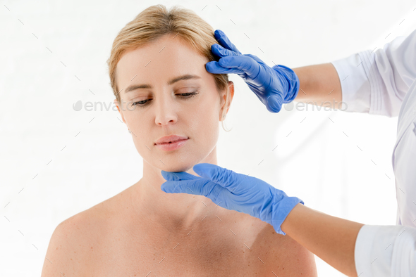 cropped view of dermatologist examining skin of patient in clinic Stock ...