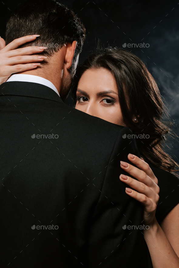 back view of man hugging young woman on black Stock Photo by ...