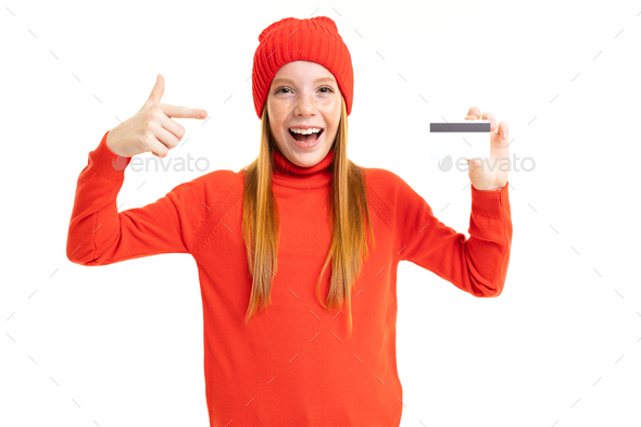 Happy teenager girl with red hair, red hoody and hat with credit card ...