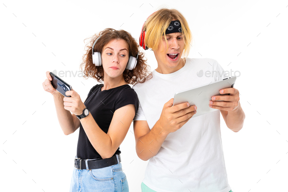 girl plays on the phone and peeps at a guy’s tablet on a white ...