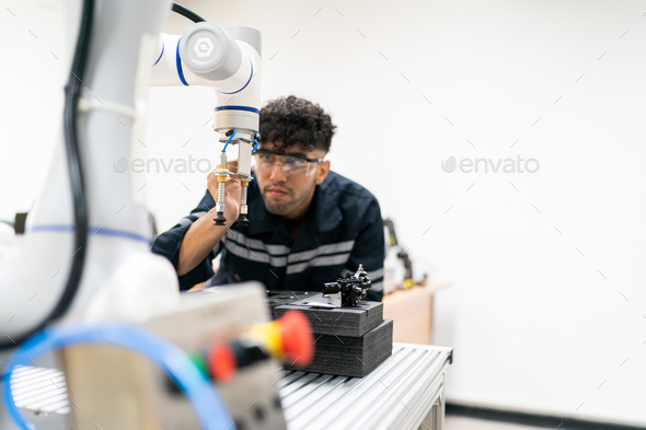 Engineer Man working at industrial robot in factory industrial. robotic ...